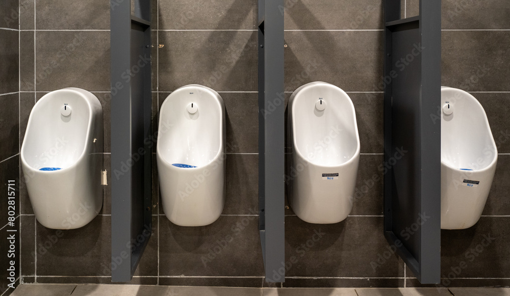 Row of modern white urinals in public restroom. Stock Photo | Adobe Stock