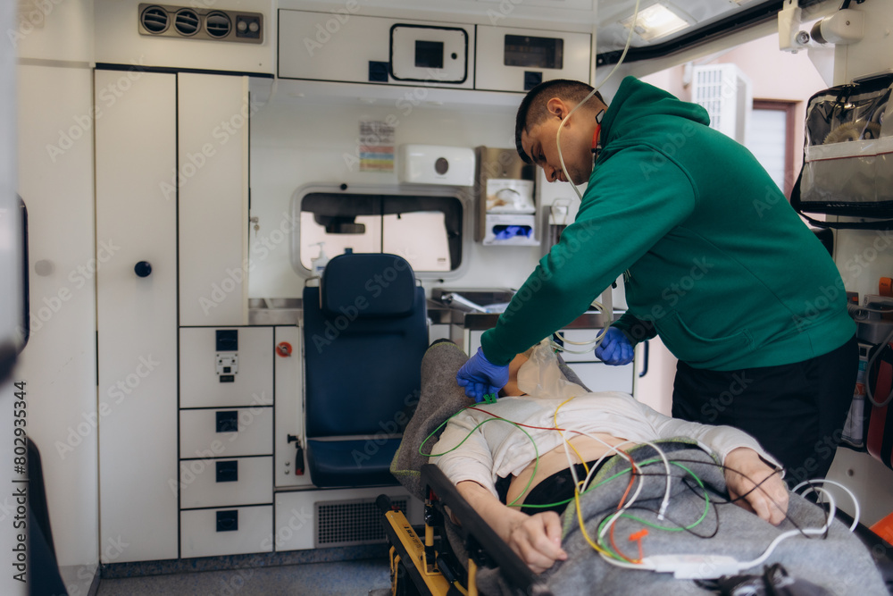 paramedic healthcare emergency staff taking care of a lying down young ...