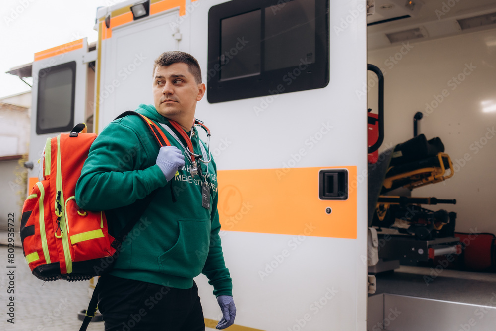 A male paramedic in uniform stands with his arms crossed in front of an ...