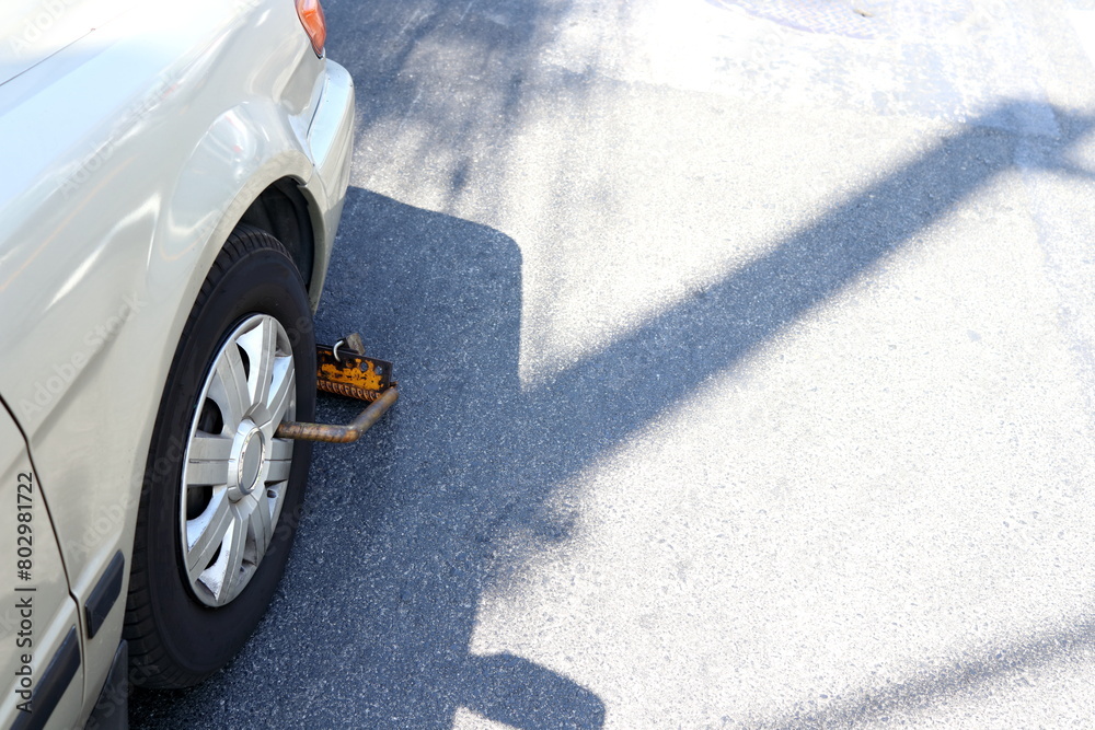 Car parking violation street area wheel locked with shadow on surface ...