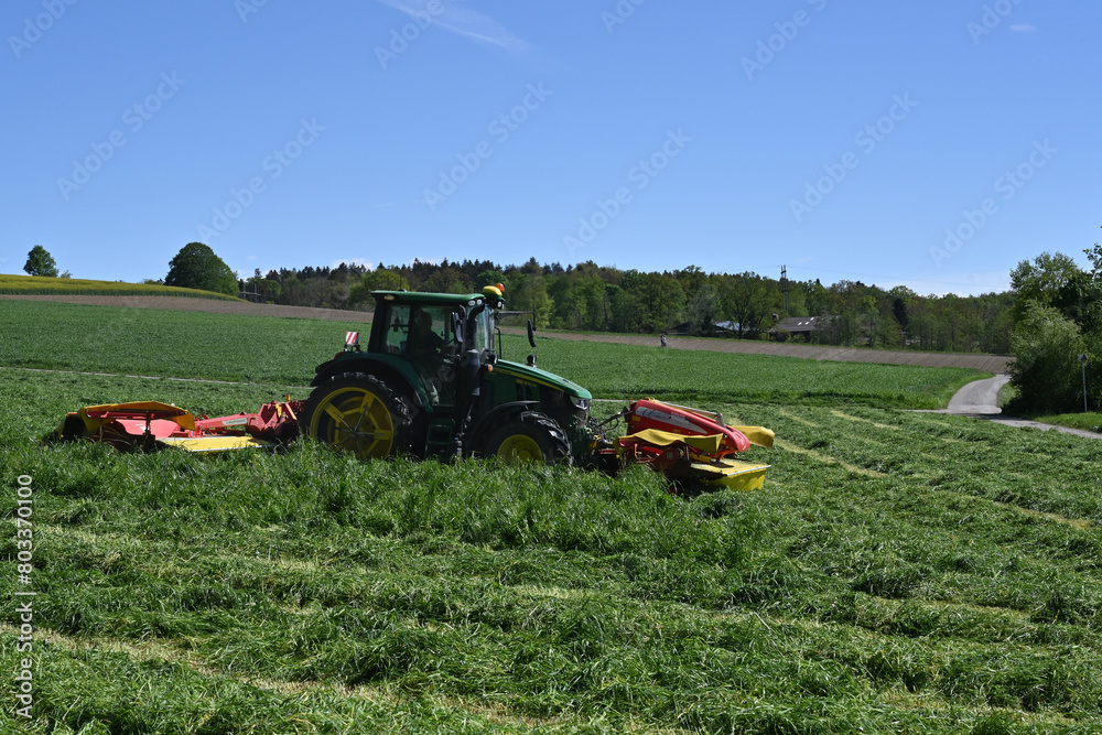 Urdorf, Switzerland, April 22, 2024: A green tractor, fitted with a ...