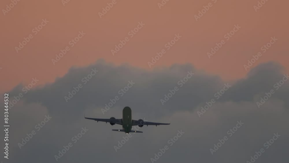 Airplane silhouette climbing in the sunset sky, rear view. Footage of ...