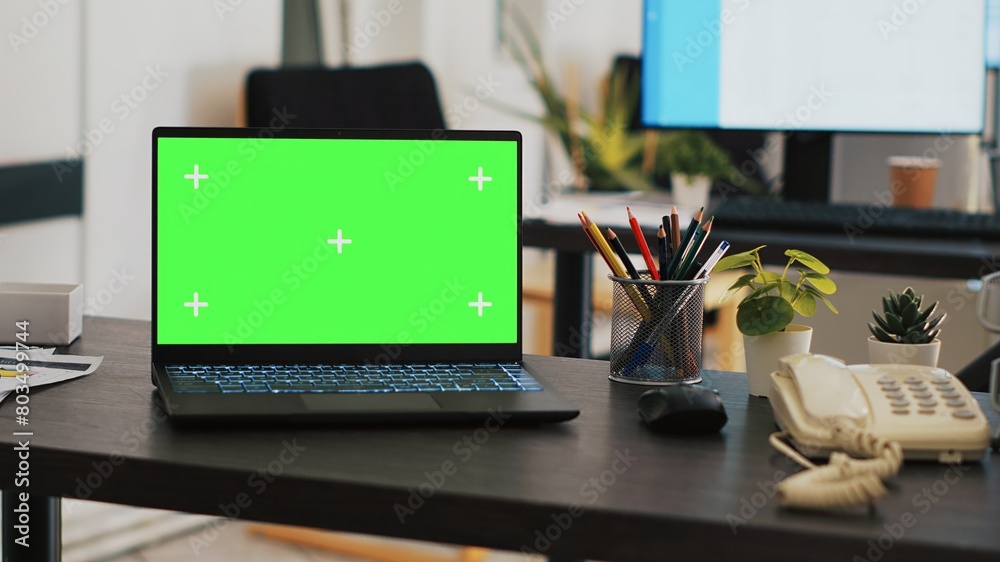Office with isolated screen laptop and display in background with ...