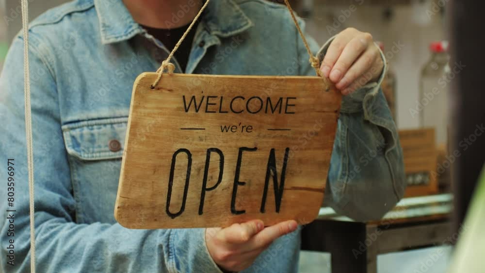 Young man worker flipping sign closed to open close-up. Turn sign to ...
