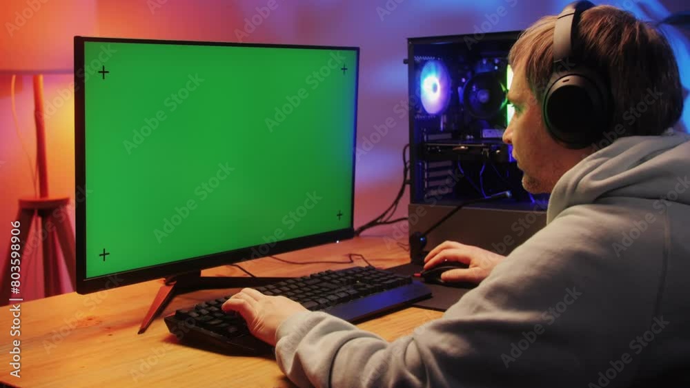 Computer with chroma key green screen on monitor. Gamer man playing in ...