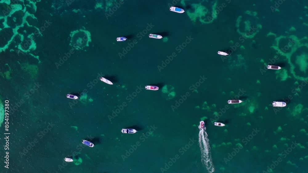 Top down aerial view of a speedboat smoothly moving between other ...