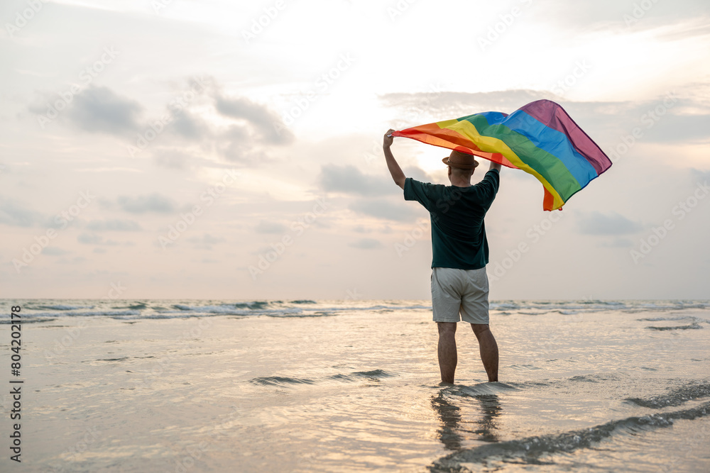 Young asian man with pride movement LGBT holding rainbow flag raise up ...