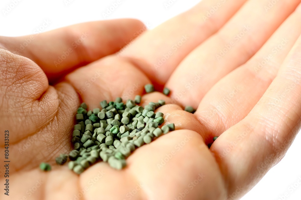 Plastc polymer granules pellets on a hand on white background ...
