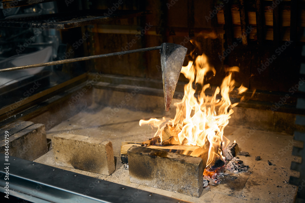 Frying some food in iron triangle pot in burning fire place in ...