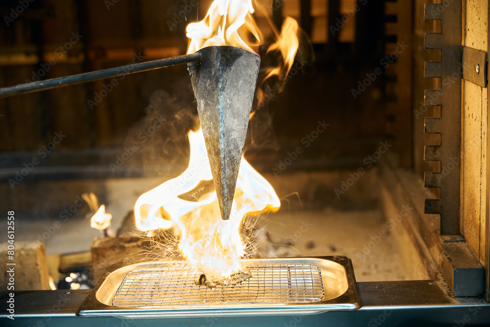 Burning iron triangle pot frying oyster on iron net tray in fire place ...