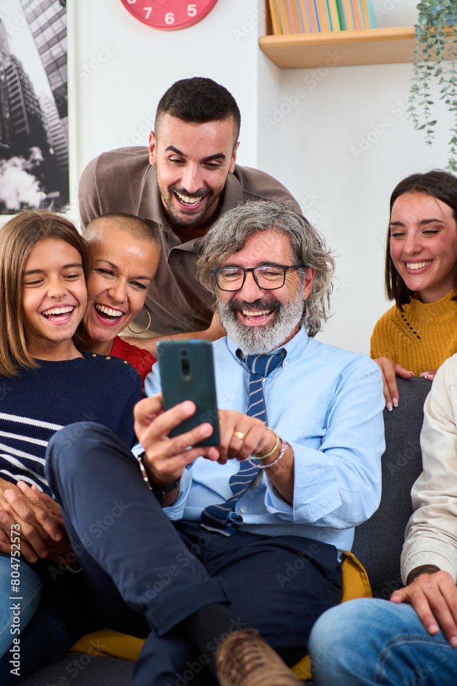Vertical. Caucasian multi-generational family gathered at living room ...