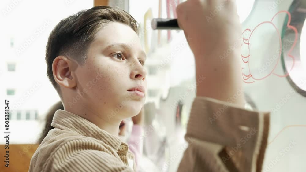 Closeup of caucasian creative student draw beautiful picture at glass ...