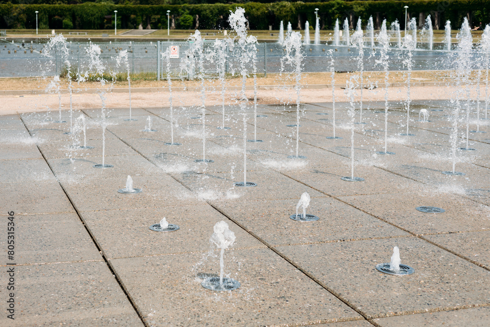 Water droplets spread from the fountain in the air. Splashing water ...