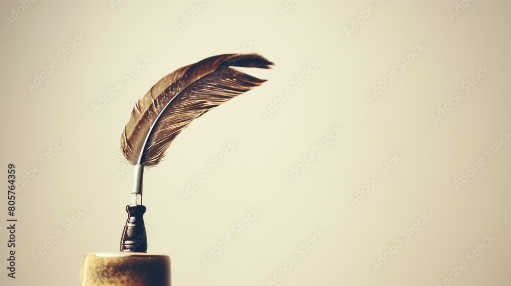An antique, feather quill pen, its tip delicately poised above an ...