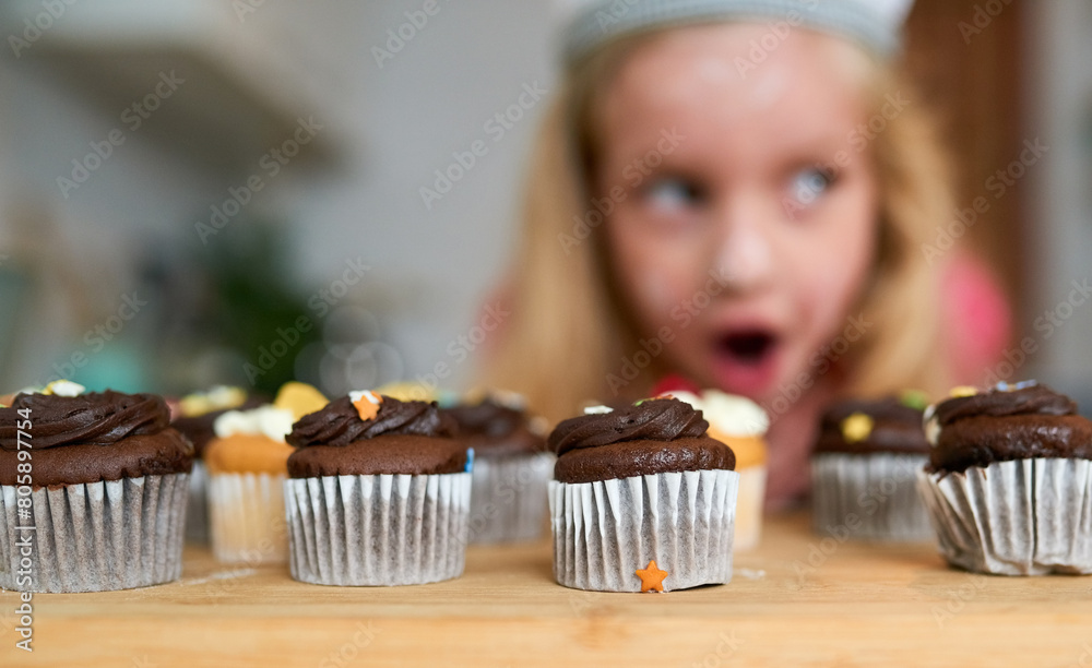 Surprise, cupcake and child at table in home and hungry for chocolate ...