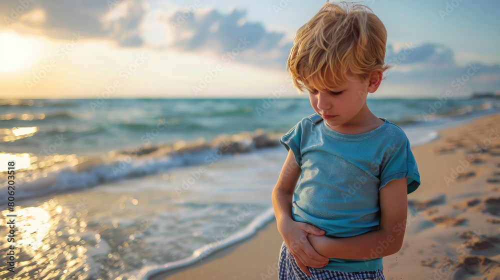 upset boy holding his sore stomach on the beach, diarrhea, poisoning ...