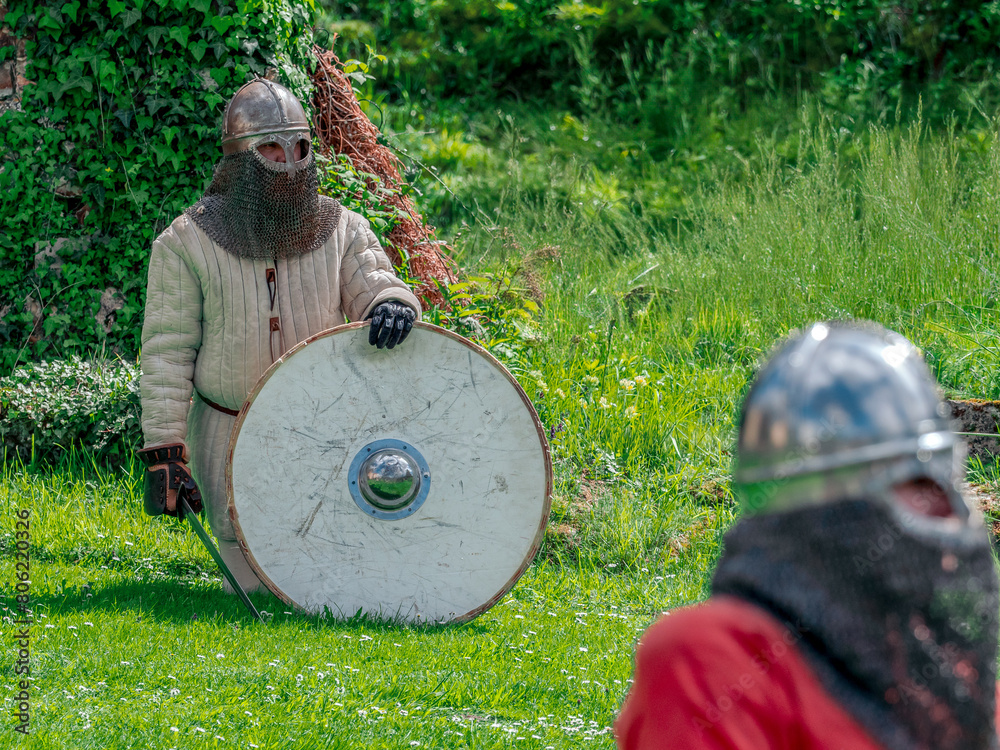 kneeling knight in armor with shield and sword on the background of ...