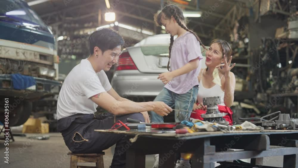Asian family of mechanic enjoy to have good activity together in garage ...