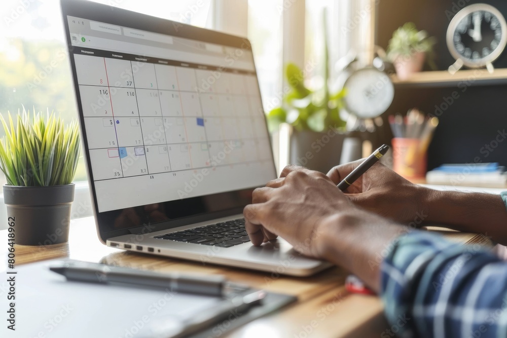Person using a digital calendar on their laptop to plan and schedule ...