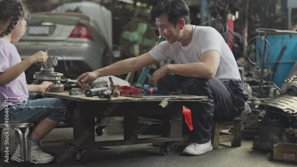 Asian family of mechanic enjoy to have good activity together in garage ...