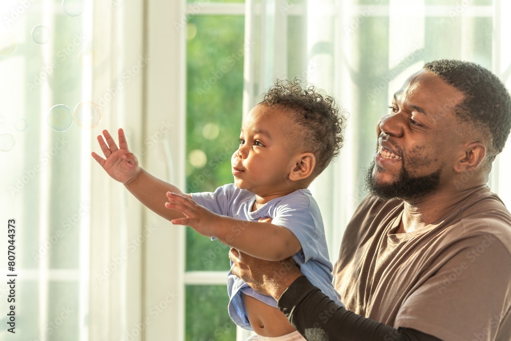 Happy african black parents dad father throw baby son on piggyback and ...