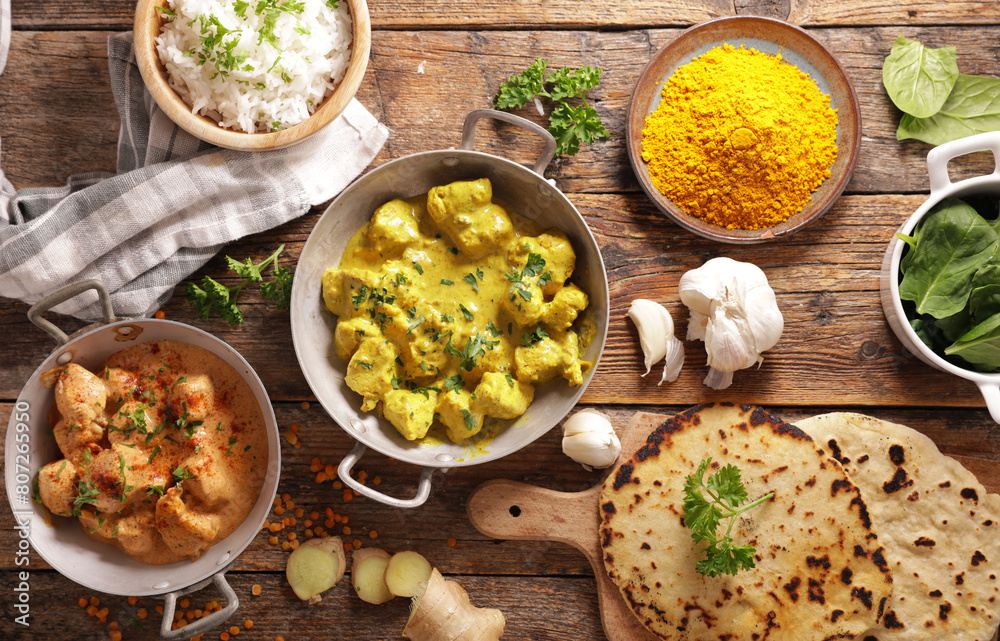 assorted of indian food- curry, chicken masala, rice, naan, spinach ...