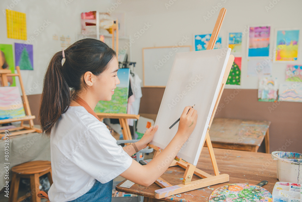 Art student drawing with watercolor painting on canvas doing some art ...