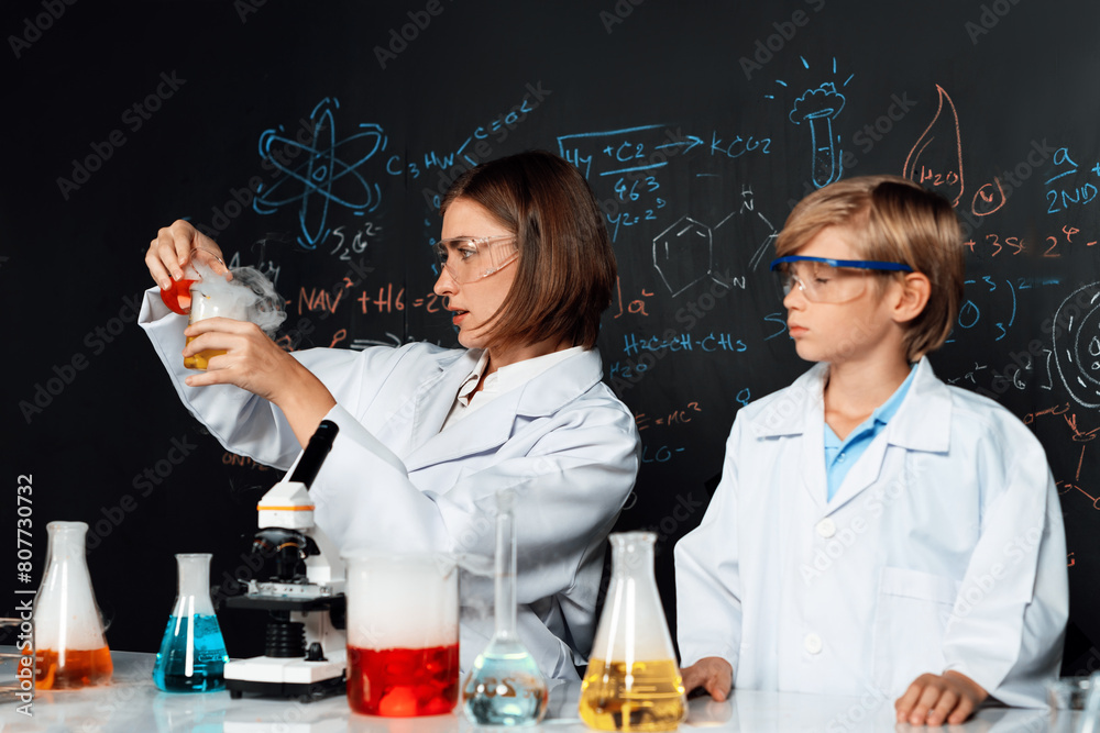 Skilled teacher and student in laboratory wear lab coat stand and ...