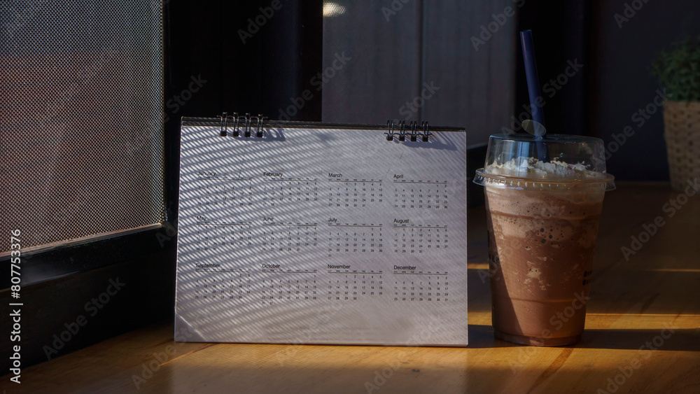 Calendar desk and iced coffee placed on business table. Desktop ...
