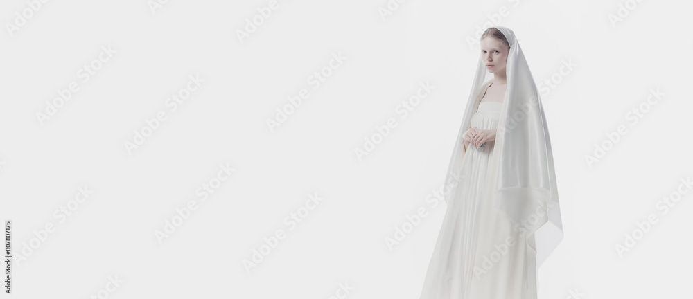 Banner. Young woman shrouded in gossamer white veil, creating ghostly yet angelic appearance ...