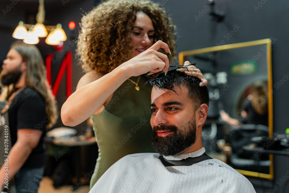 Barber applying styling techniques on a cheerful male customer ...