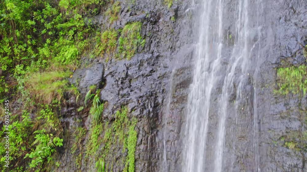 aerial footage up the rock face of a very high steep waterfall in the ...