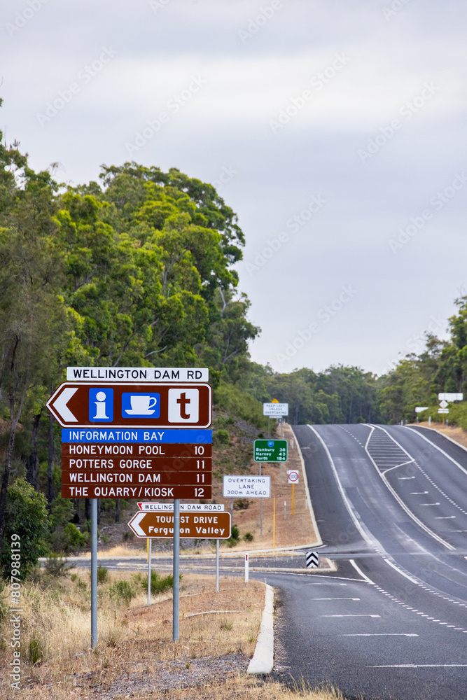 Wellington Dam Road turnoff on highway with many signs at the ...