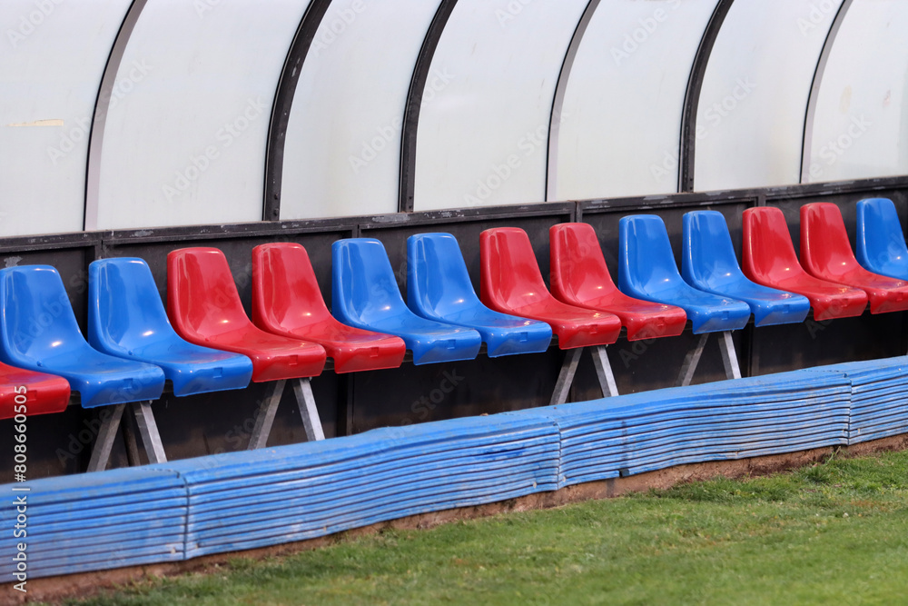 Bench of a football stadium with red and blue seats. No players Stock ...