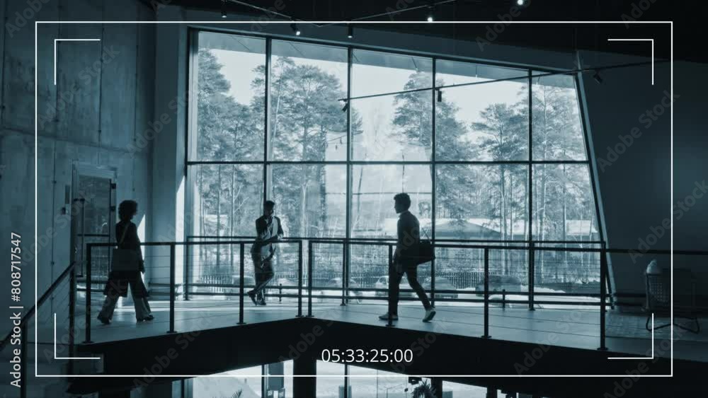 Wide CCTV footage of diverse businesspeople arriving for work, walking ...