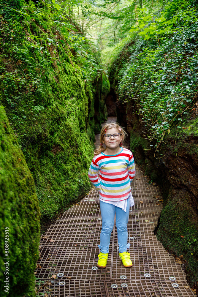 Happy little preschool girl hiking through a cave. Child having fun ...