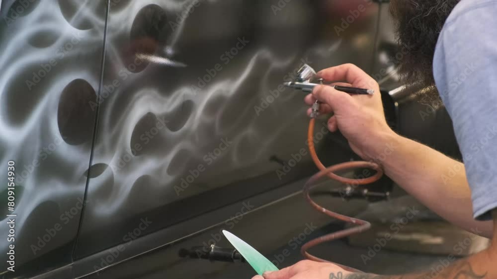 Tattooed man hands airbrushing of car body from door side. Lifehack how ...