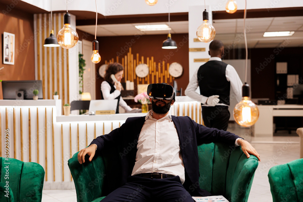 Businessman works with vr headset in hotel lobby, using new 3d ...