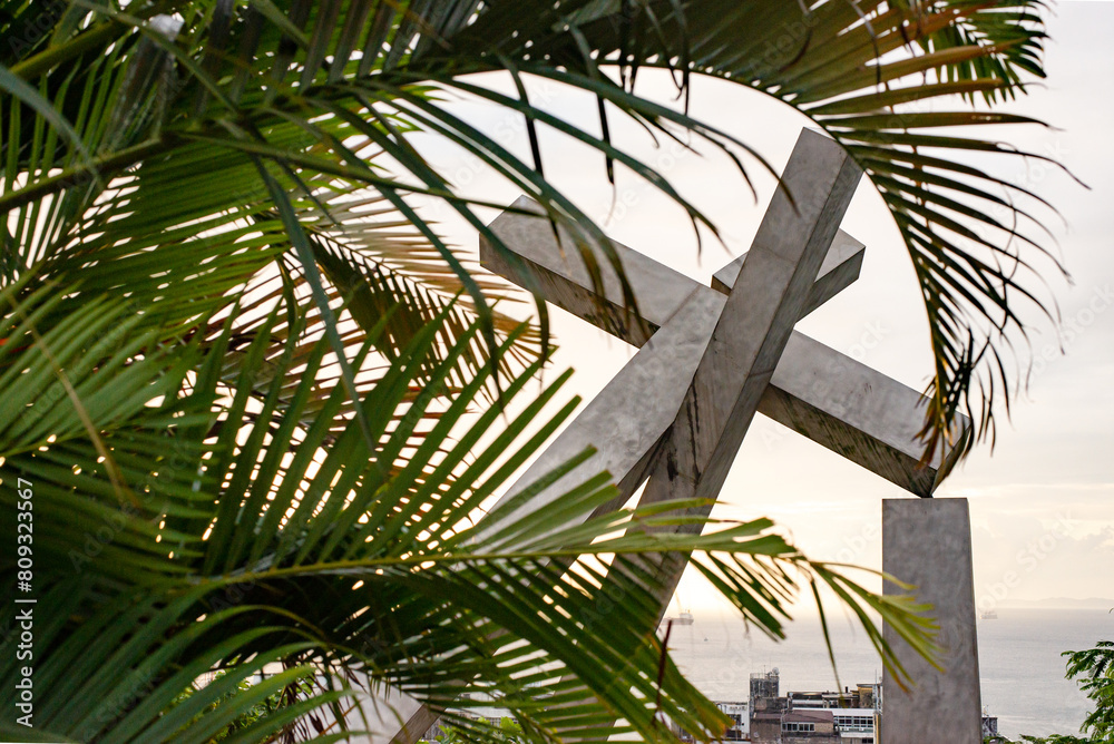 View, through the palm leaves, of the fallen cross monument in the ...