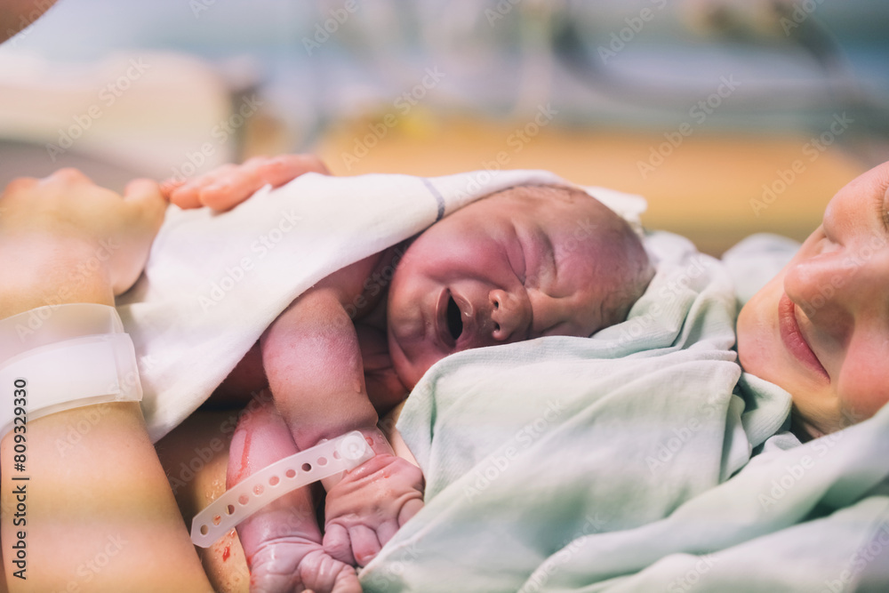 Mother and newborn. Child birth in maternity hospital. Young mom ...