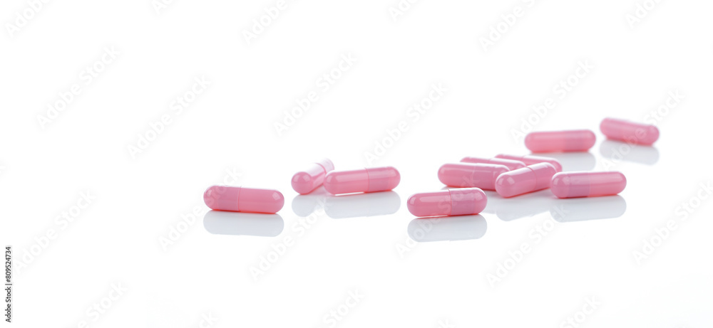 Pink capsules pill spread on white background. Prescription drug ...