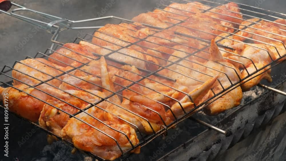 Delicious chicken frying on barbecue grill grate outdoor. Seasoning ...
