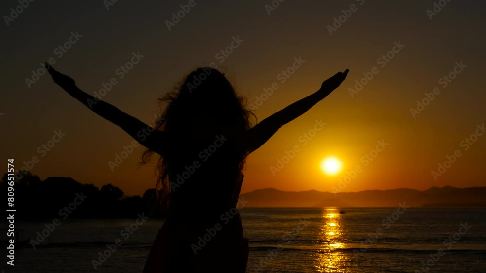 Little yoga girl on evening shore. A little girl silhouette with open ...