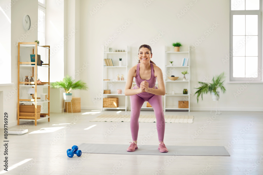 Portrait of a sporty athletic young woman exercising at home on the ...