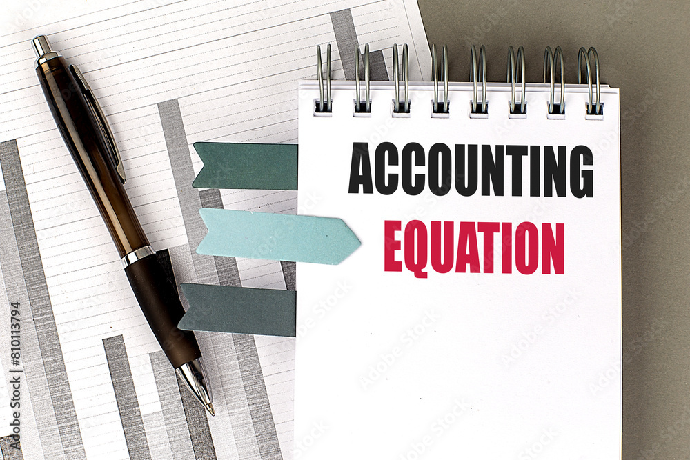 ACCOUNTING EQUATION text on notebook with chart on gray background ...