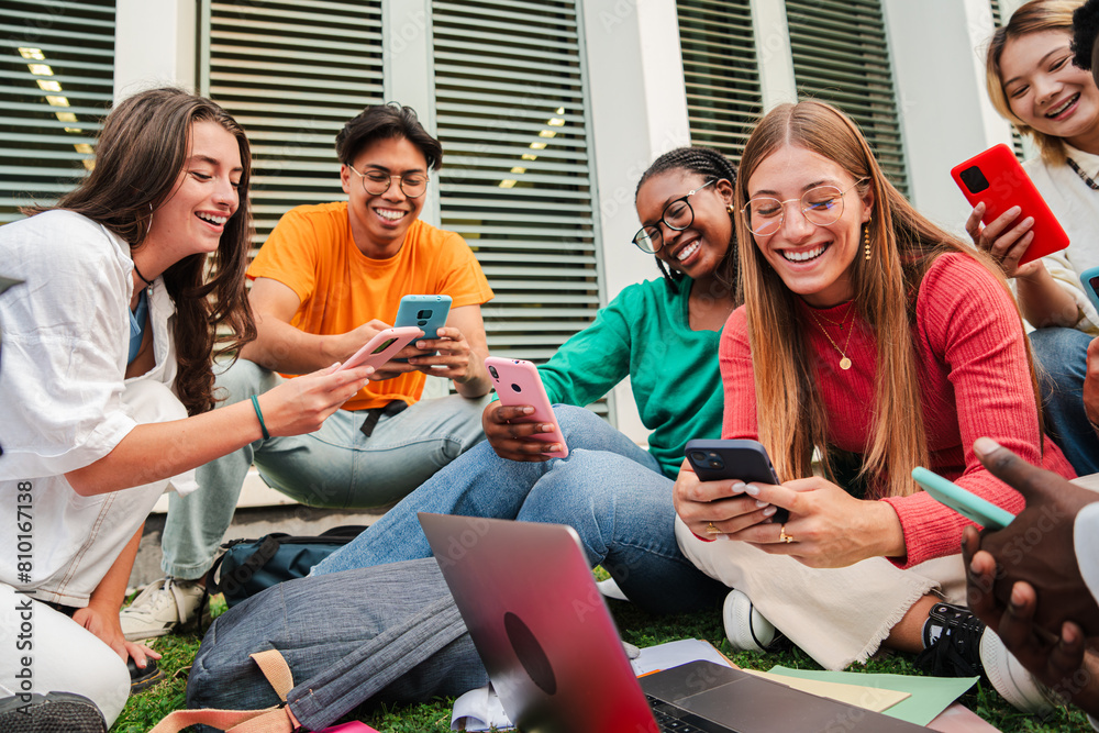 Group of students sitting on the university campus lawn, having fun ...