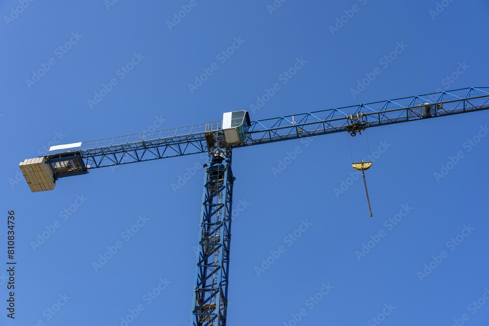 Construction crane against the sky. Tall blue tower crane. Construction ...