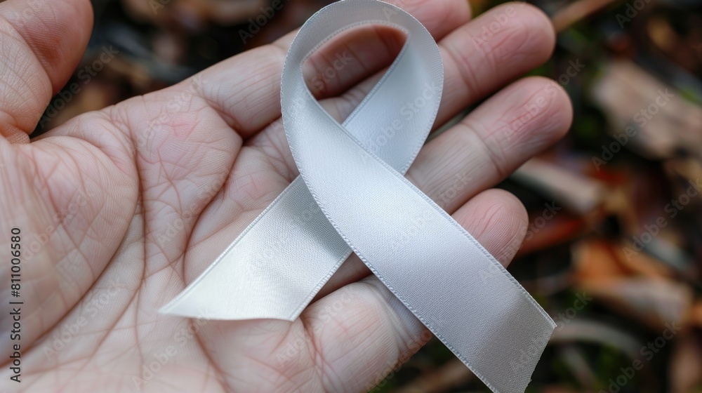 Silver ribbon worn on a person s hand represents support and awareness ...