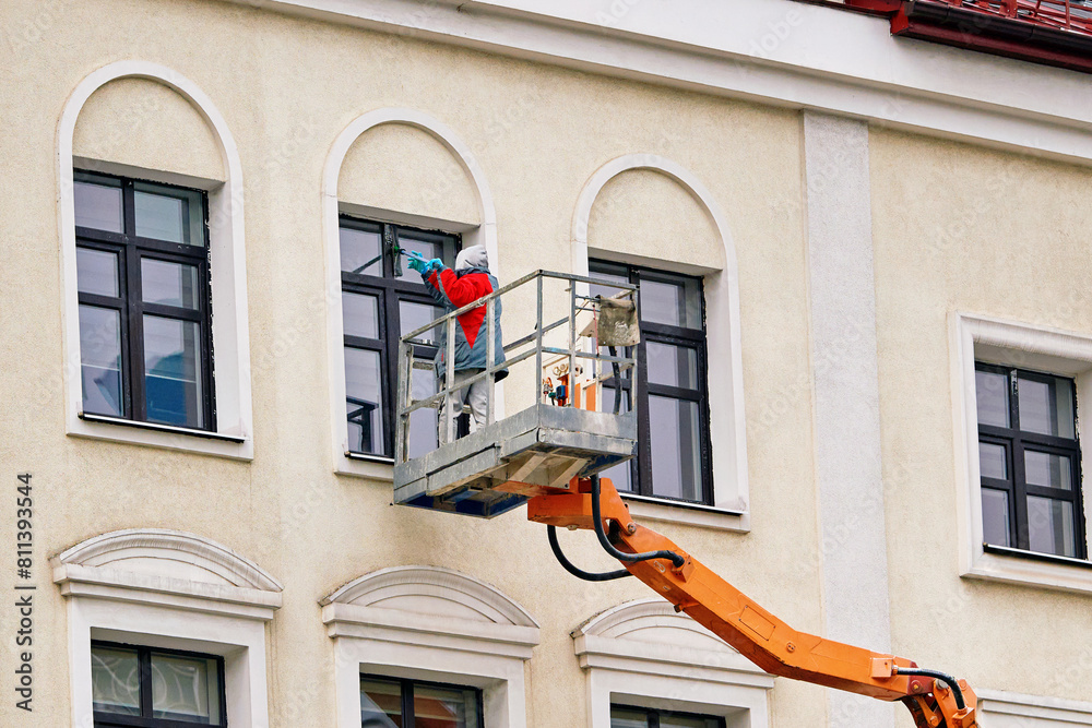 Industrial alpinist wash windows, facade maintenance. Cleanup service. Worker washing windows ...