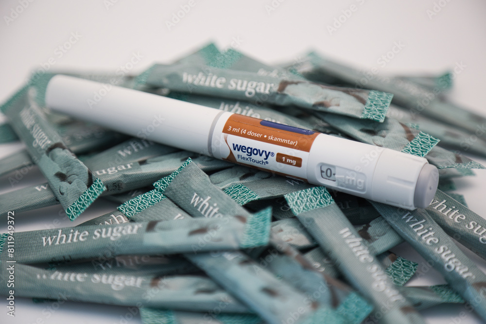 Wegovy Semaglutide injection pen 1 mg on top of pile of sugar packages ...